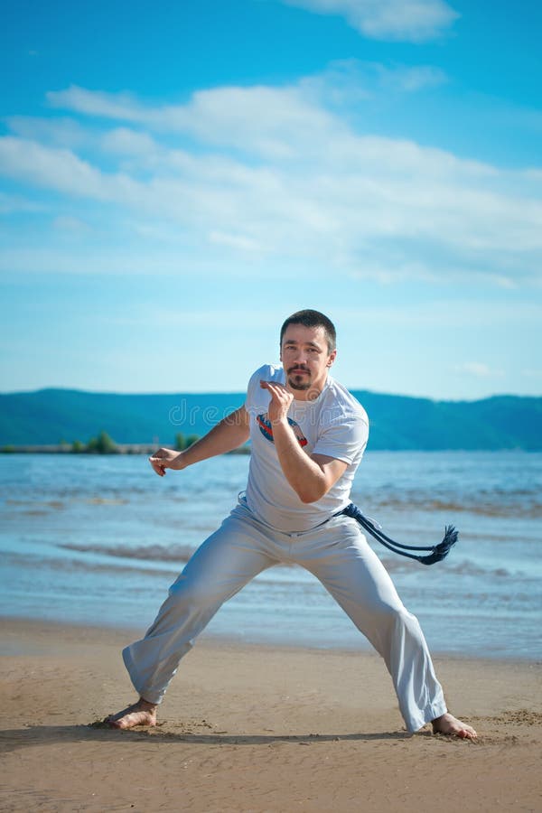 Man Practicing Capoeira on the Beach. the Man Does the Fighting Element ...