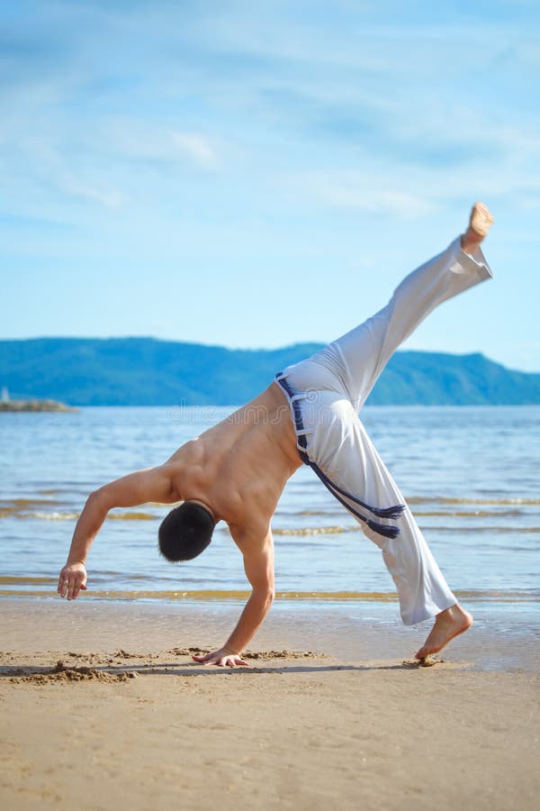 Man Practicing Capoeira on the Beach. the Man Does the Fighting Element ...