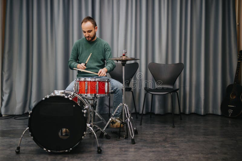 Man Practicing Drumming on a Red Drum Set in a Music Studio Stock Image ...