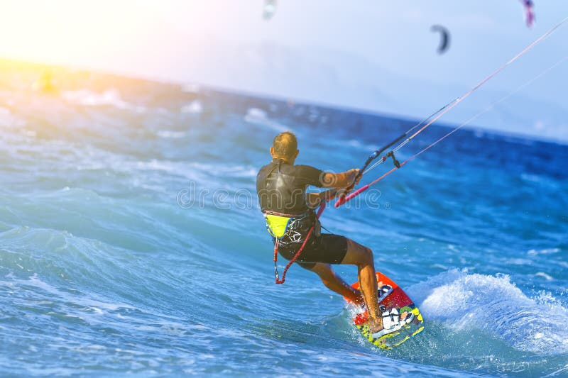 Man Kitesurfer Riding the Waves with Strong Winds. Bright Sunny Day ...