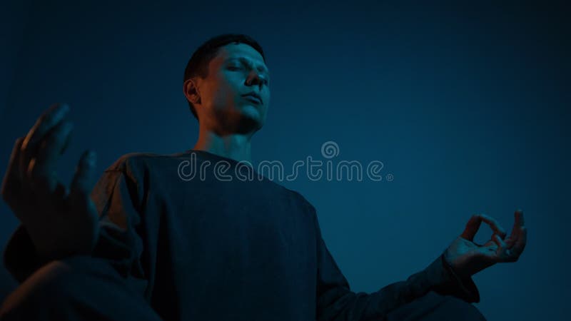 Man Practicing Meditation at Night with Atmospheric Lighting, His Hands ...