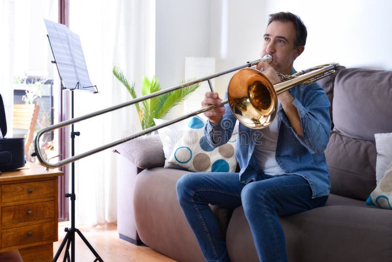 Man Practicing Trombone with Enthusiasm in Living Room at Home Stock ...