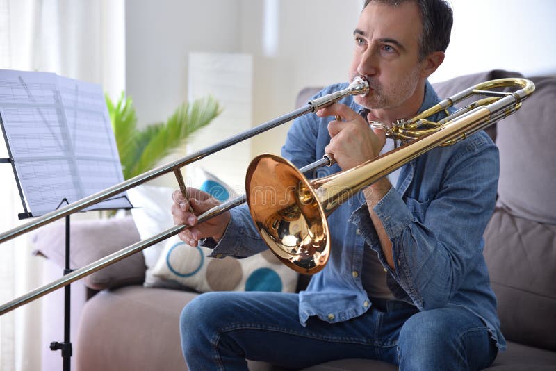 Man Practicing Trombone in a Sofa at Home Stock Image - Image of male ...