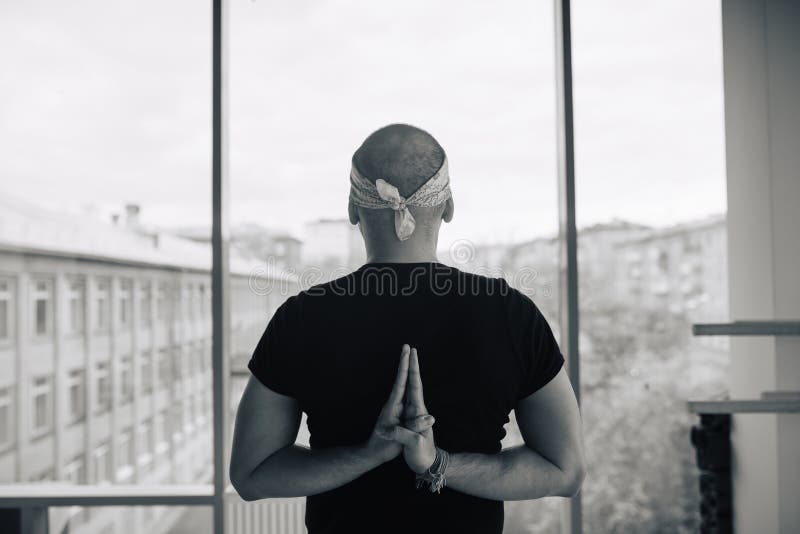 Man Practicing Yoga Meditation Pose, Looking To the Street through a ...