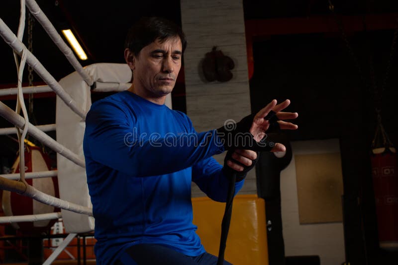 A Man Prepares for a Boxing Training Session. he Wraps His Hands with ...