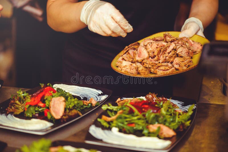 Man Prepares Meat in a Restaurant Kitchen, Hands Lay Out Meat on Plates ...