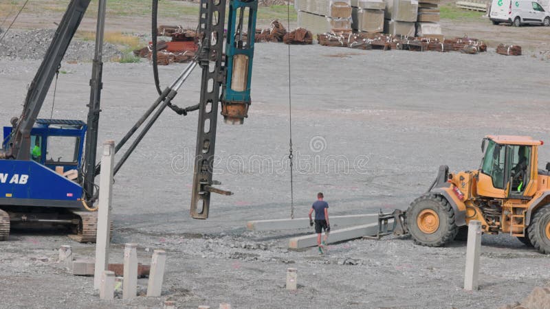 Man Prepares Piles for Driving into Ground with Pile Driver Machine ...