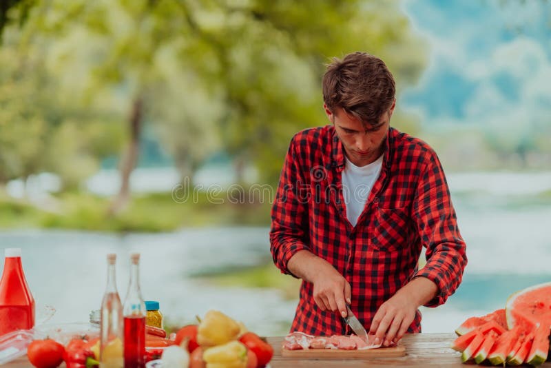 A Man Preparing a Delicious Dinner for His Friends Who are Having Fun ...