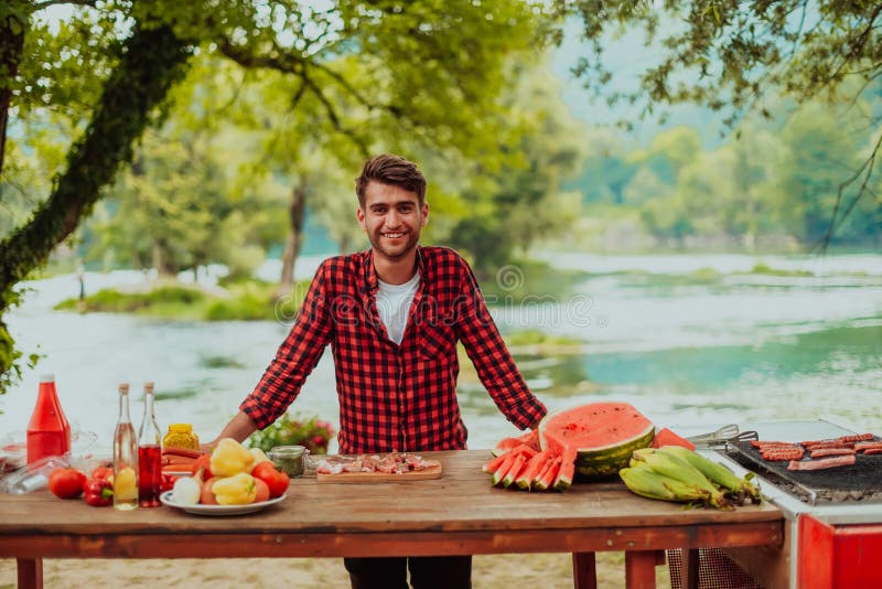 A Man Preparing a Delicious Dinner for His Friends Who are Having Fun ...