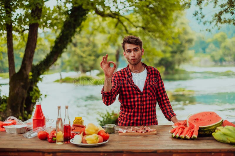 A Man Preparing a Delicious Dinner for His Friends Who are Having Fun ...