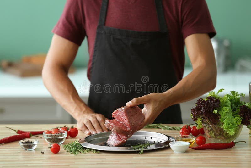 Man Preparing Raw Meat with Fresh Spices in Kitchen Stock Photo - Image ...