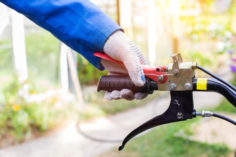 A Man Presses the Handle of the Safe Shutdown of a Walk-behind Tractor ...