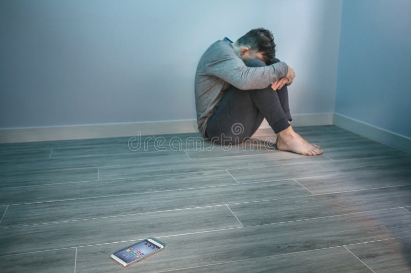 Man with Problems Sitting on the Floor with Mobile on the Floor Stock ...