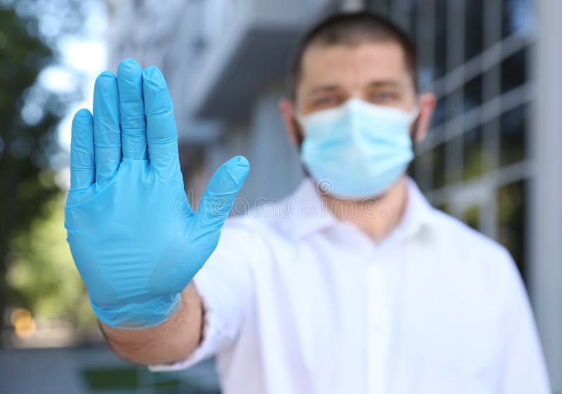 Man in Protective Face Mask Showing Stop Gesture Outdoors, Focus on ...