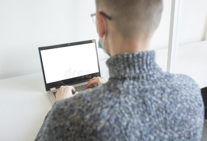 Man in Protective Face Mask Working on Laptop Computer. Screen of ...