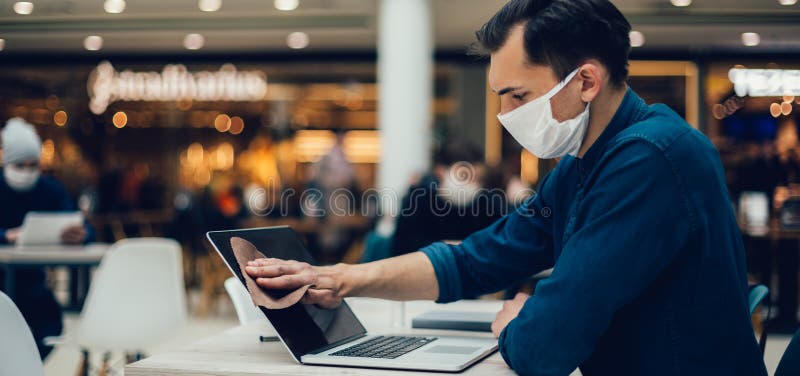 Man in a Protective Mask Wiping the Laptop Screen with Antiseptic ...