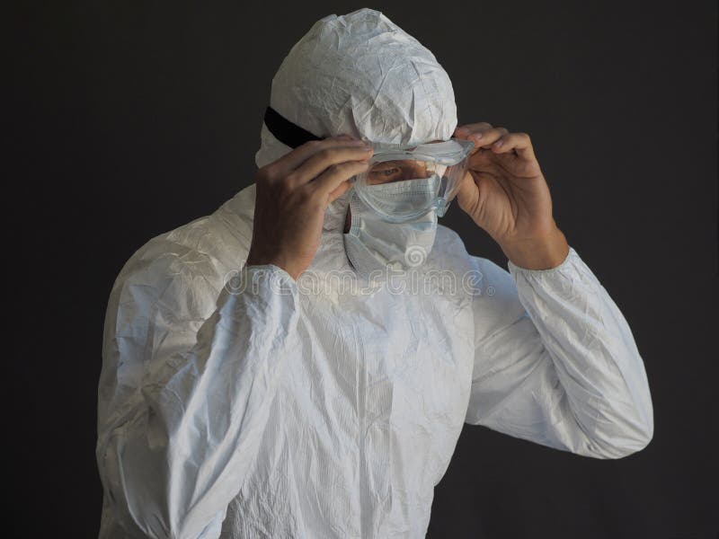 Man in Protective Suit and Face Mask Puts on Goggles. Stock Image ...