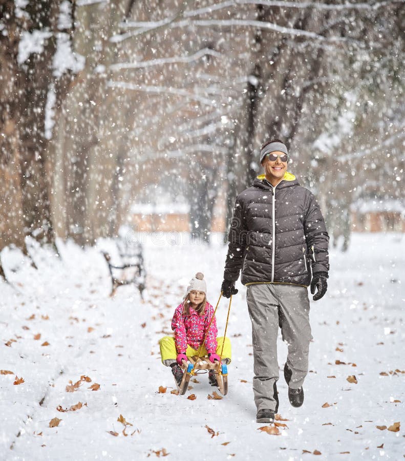 Man Pulling a Child on a Wooden Sled in a Park Stock Photo - Image of ...