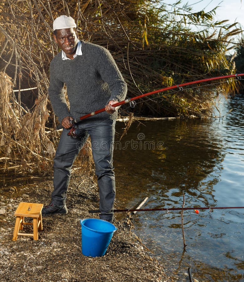 Man and Pulling Fish Near River Stock Photo - Image of friendly, forest ...