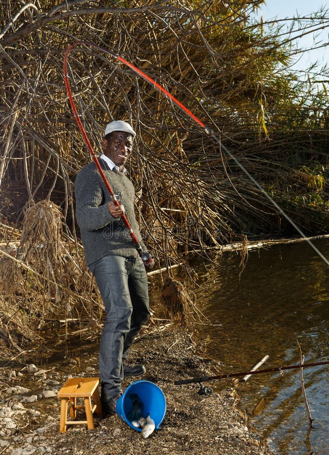 Man and Pulling Fish Near River Stock Image - Image of fish, natural ...