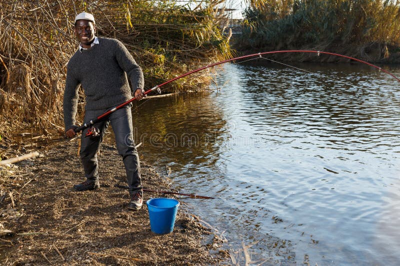 Man pulling fish on hook stock image. Image of person - 220811121