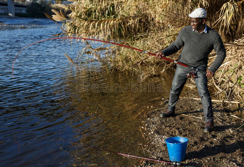 Man and Pulling Fish Near River Stock Photo - Image of catch, lifestyle ...