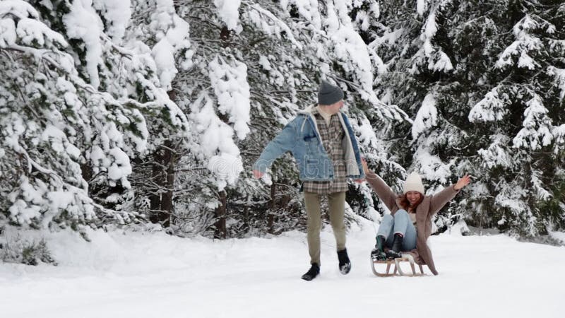 Man Pulling Sled with His Girlfriend in Winter Forest Stock Footage ...