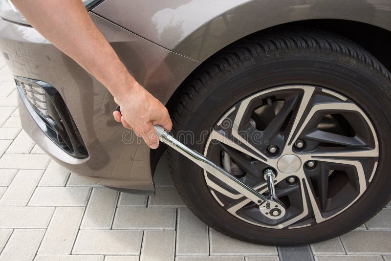 Man Pulling in Tire with a Torque Moment Wrench Stock Photo - Image of ...