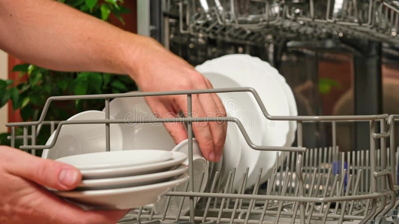 Man Pulls Out Dishwasher Basket and Unloads Clean Plates. Release of ...