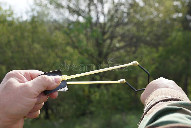 Man Pulls a Slingshot for a Shot in the Forest, Close-up of Hands Stock ...