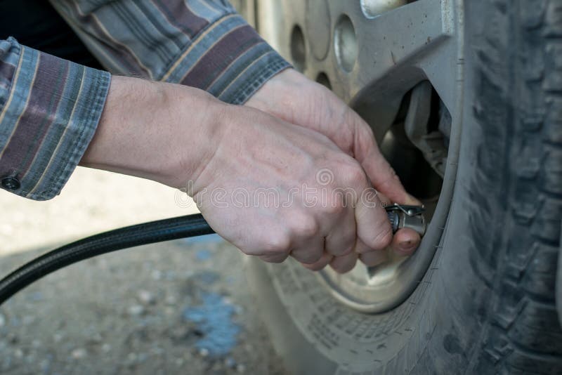 Man pumps the car wheel stock image. Image of people - 129929061