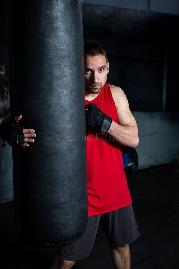 Man Punching a Boxing Bag stock photo. Image of biceps - 195096760