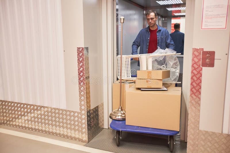 Man Pushing Cart Out of Elevator Stock Image - Image of business ...