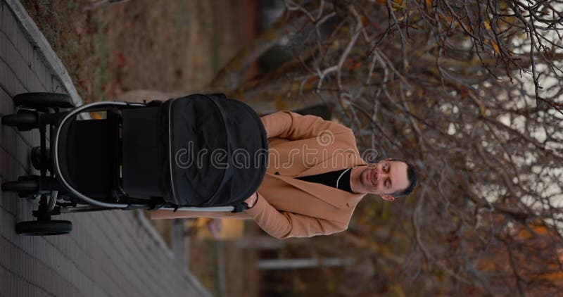 A Man Pushing a Stroller with a Child while Walking in the Park ...