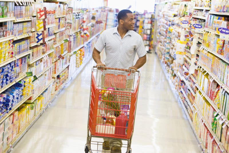 Man Pushing Trolley Along Supermarket Aisle Stock Photo - Image of ...