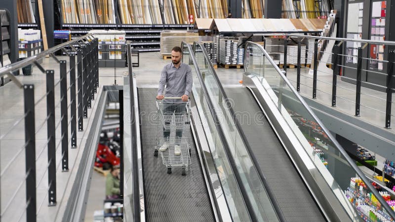 A Man Pushing Trolley on Escalator in Hardware Store Stock Footage ...