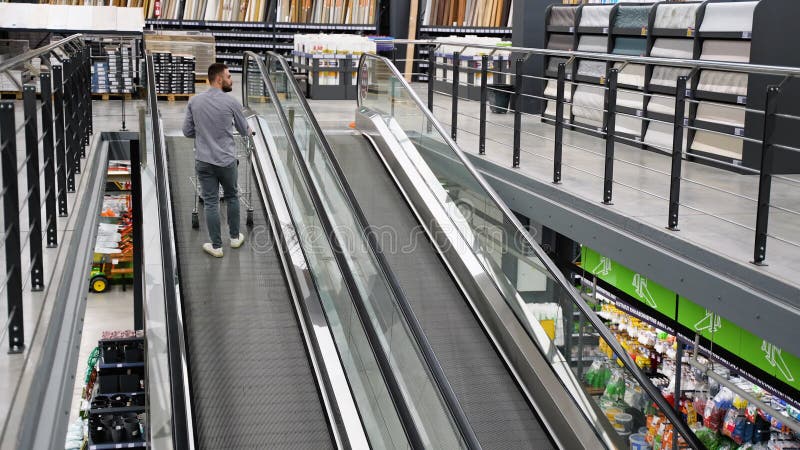 A Man Pushing Trolley on Escalator in Hardware Store Stock Footage ...
