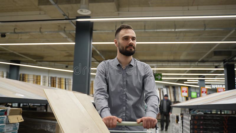A Man Pushing Trolley with New Laminate in Hardware Store Stock Footage ...