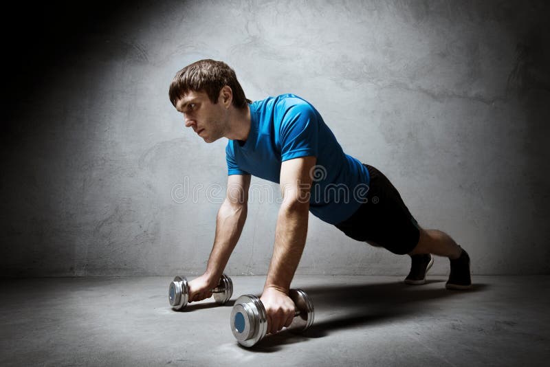 Man Pushing Up from the Dumbbells on Wall Backdrop Stock Photo - Image ...