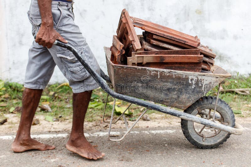 A Man is Pushing a Wheelbarrow Full of Bricks Stock Photo - Image of ...