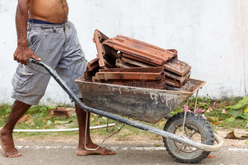 A Man is Pushing a Wheelbarrow Full of Bricks Stock Photo - Image of ...