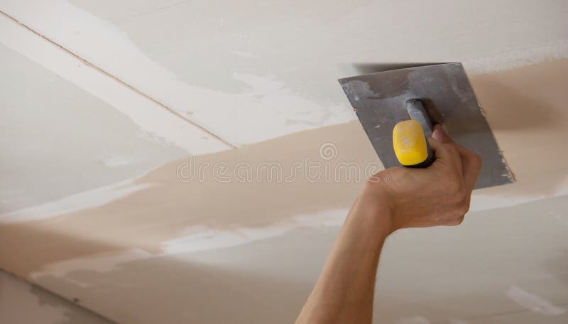 A Man Puts Putty on a Plasterboard Ceiling. Putty for the Joints of ...
