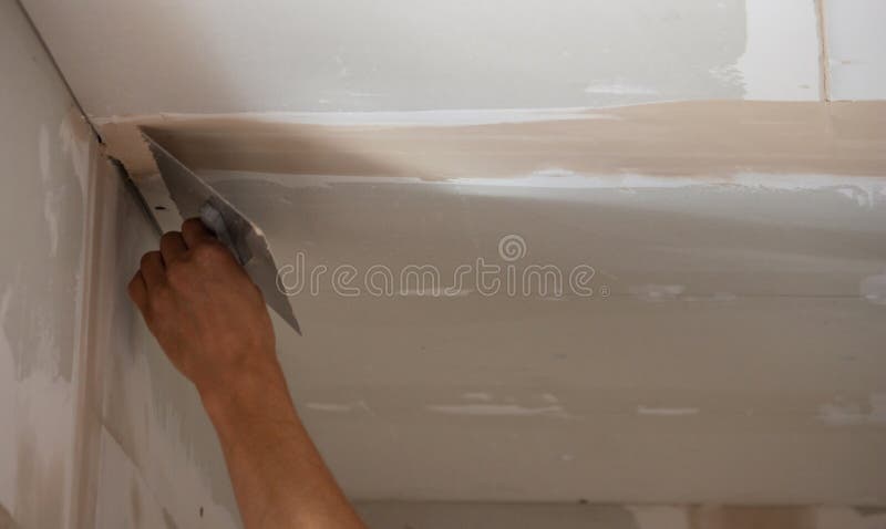 A Man Puts Putty on a Plasterboard Ceiling. Putty for the Joints of ...