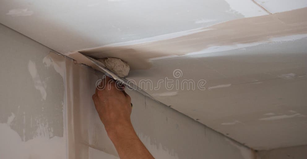 A Man Puts Putty on a Plasterboard Ceiling. Putty for the Joints of ...