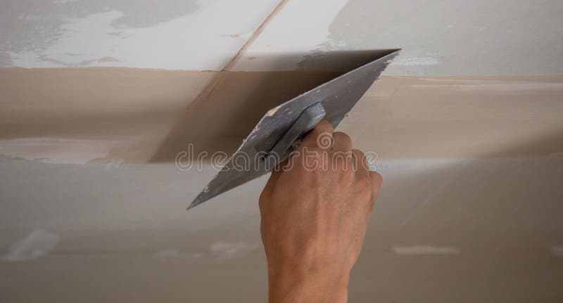 A Man Puts Putty on a Plasterboard Ceiling. Putty for the Joints of ...