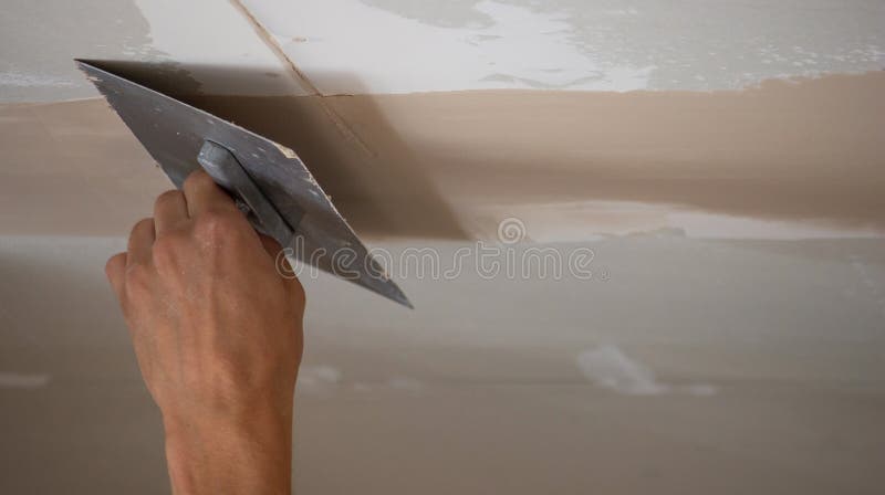 A Man Puts Putty on a Plasterboard Ceiling. Putty for the Joints of ...