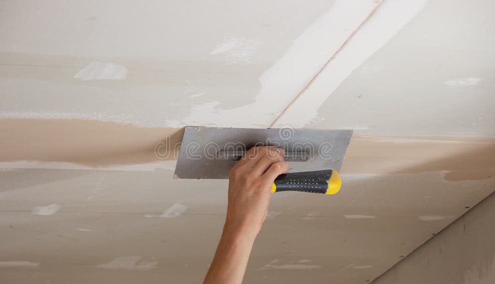 A Man Puts Putty on a Plasterboard Ceiling. Putty for the Joints of ...
