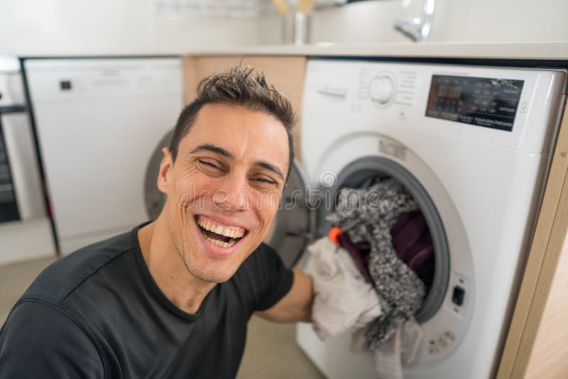Man Putting Clothes in the Washing Machine Stock Photo - Image of smile ...