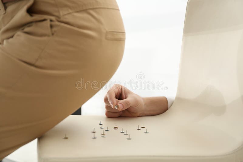 Man Putting Pins on Chair while His Colleague Sitting Down. April Fool ... Man Putting Pins on Chair while His Colleague Sitting Down. April Fool ...