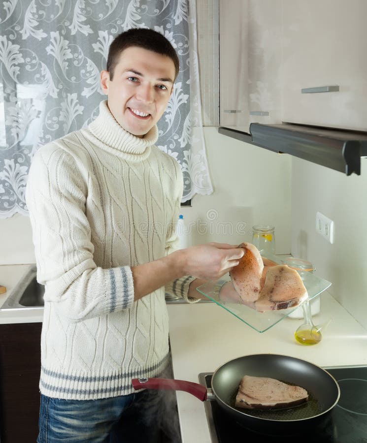 Man Putting Raw Steak of Fish into Frying Pan Stock Photo - Image of ...